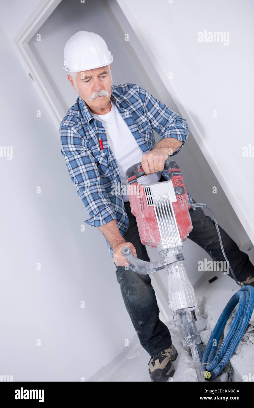 Senior man using pneumatic drill Stock Photo - Alamy