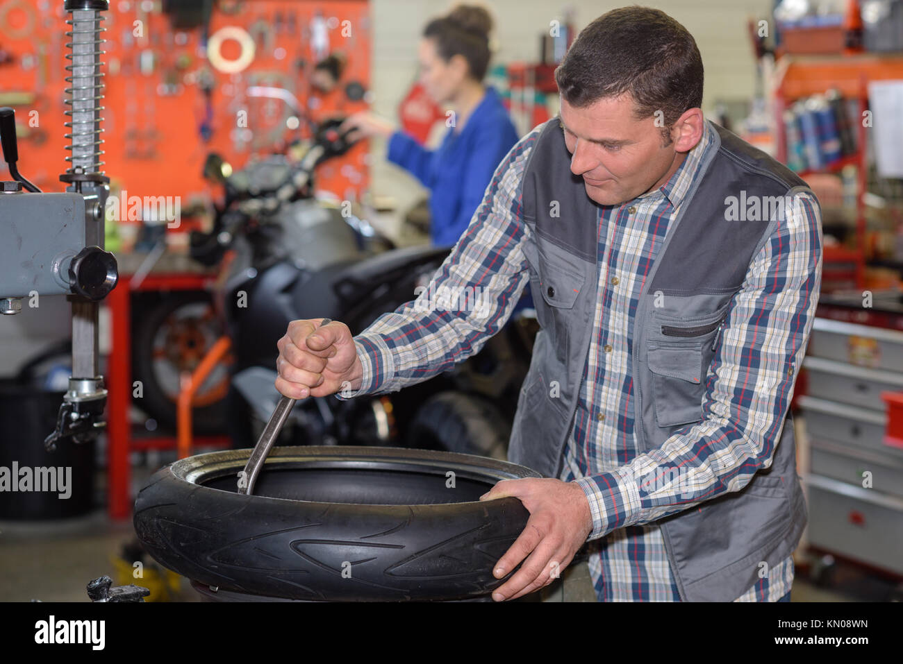 mechanic repairing tyre Stock Photo - Alamy