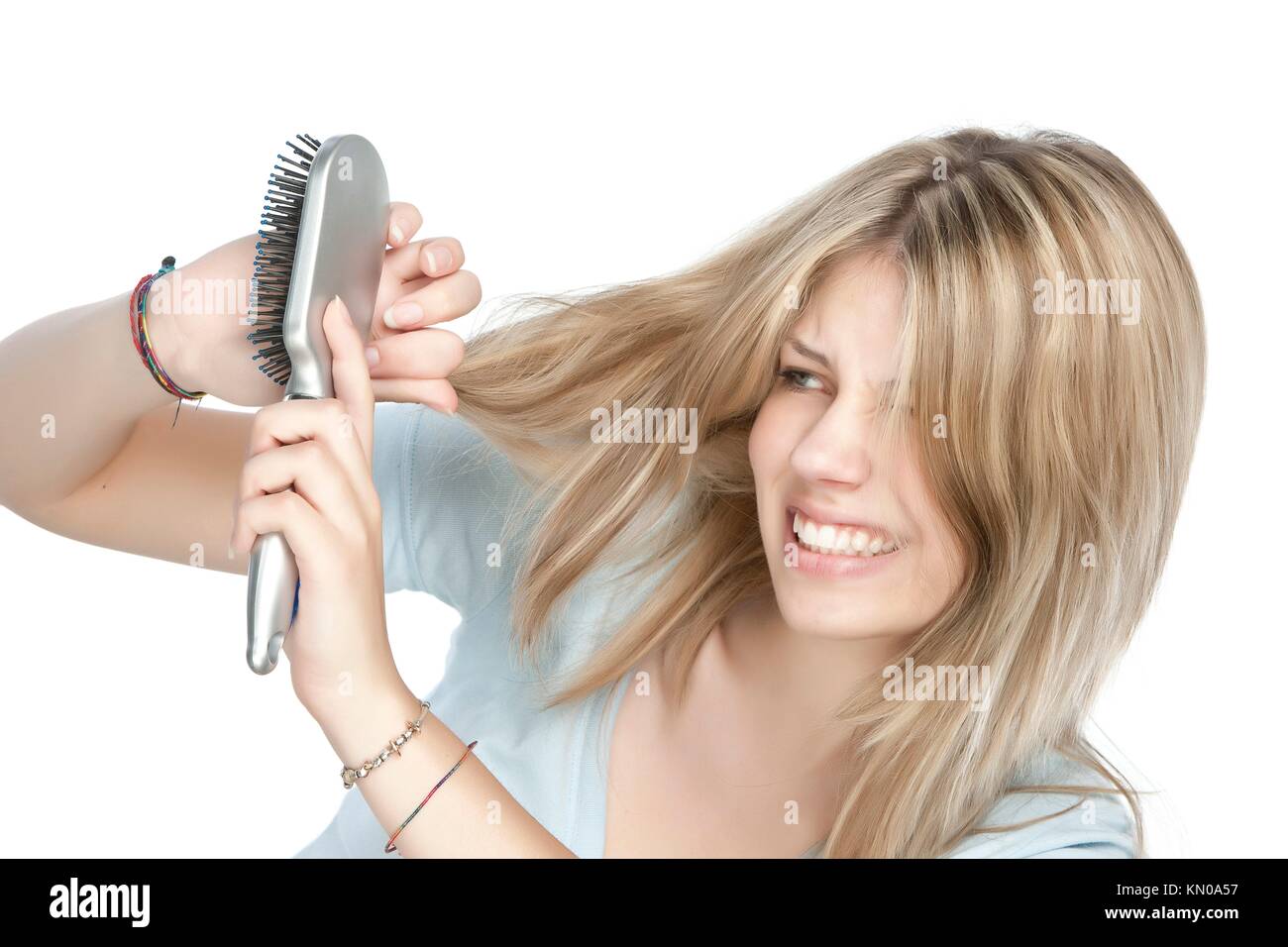 Beautiful young woman combing her hair Stock Photo - Alamy