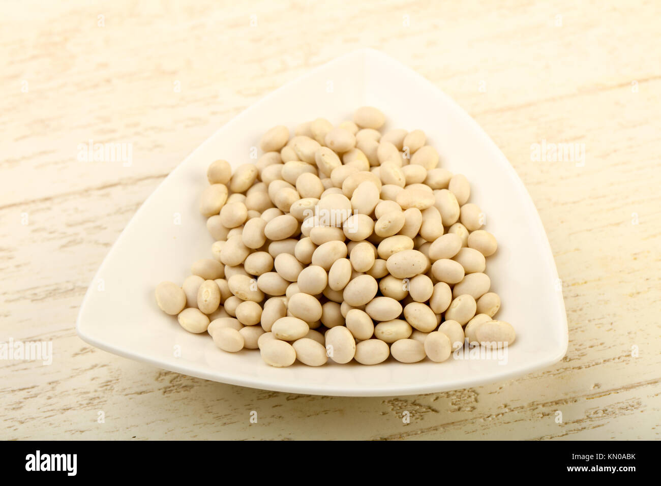 Dry white beans in the bowl over wooden background Stock Photo - Alamy