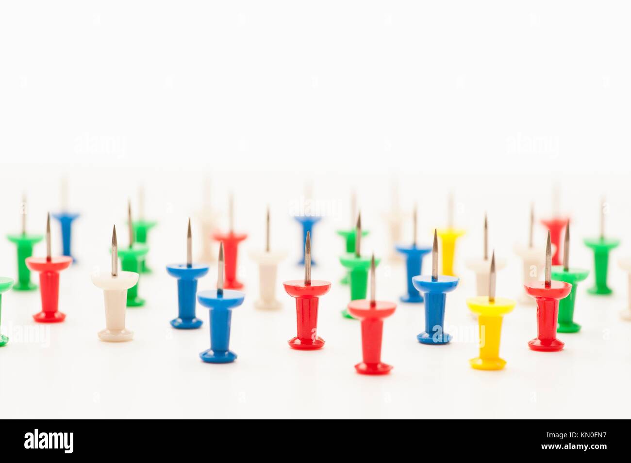 Many colorful push pins with the sharp end pointing up Stock Photo - Alamy