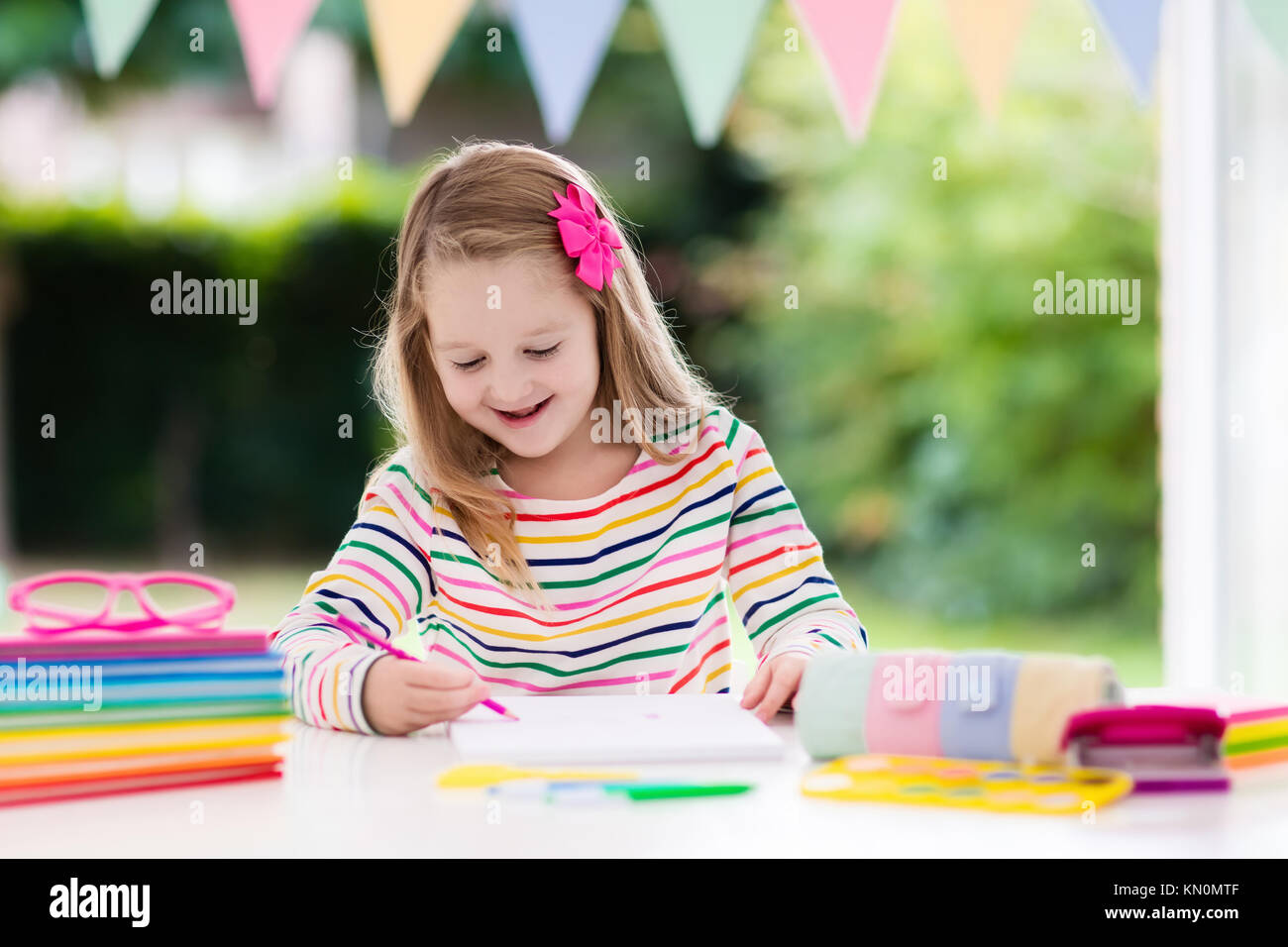 Child doing homework for school at white desk. Little girl with school ...