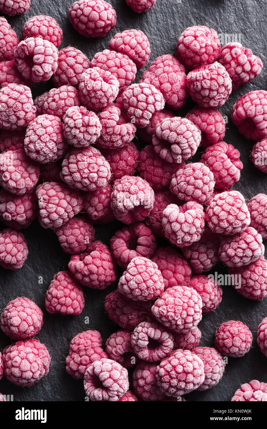 Frozen raspberry on black slate. Top view. High resolution product ...