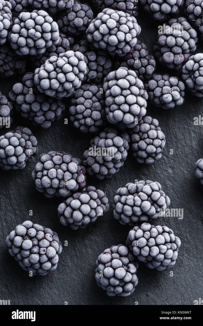 Frozen blackberry on black slate. Top view. High resolution product ...