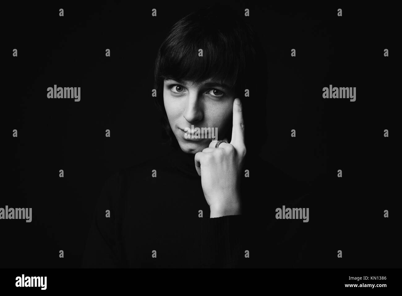 Young handsome man pointing finger at his temple meaning on a dark ...