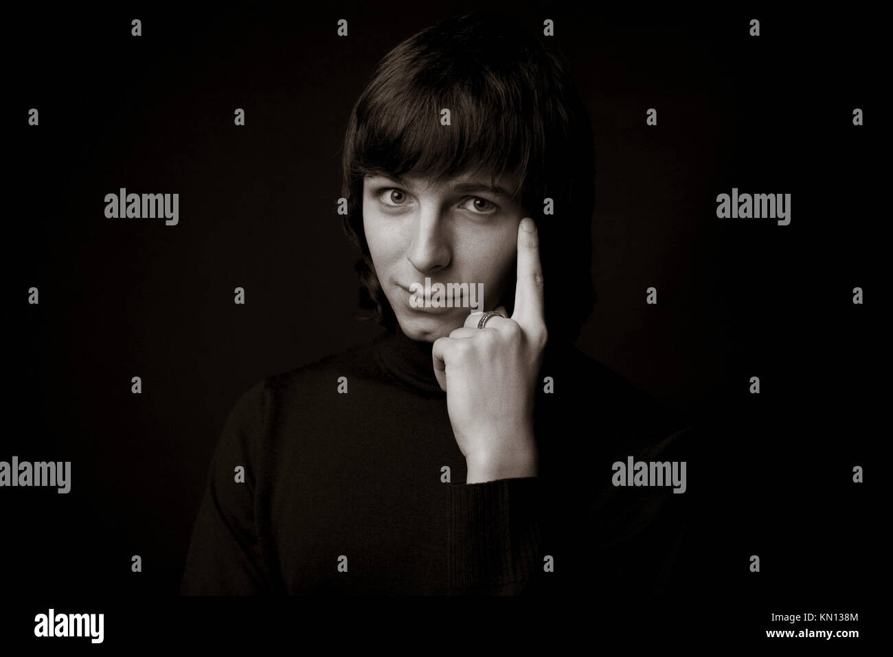 Young handsome man pointing finger at his temple meaning on a dark ...