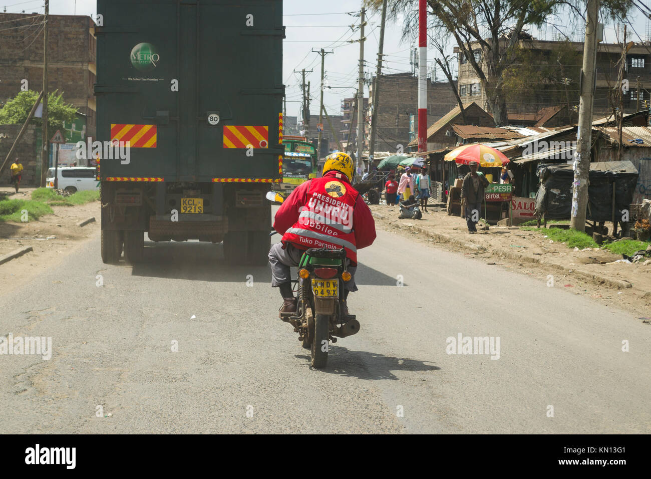 A boda boda motorbike rider with an Uhuru Kenyatta Jubilee Party jacket ...