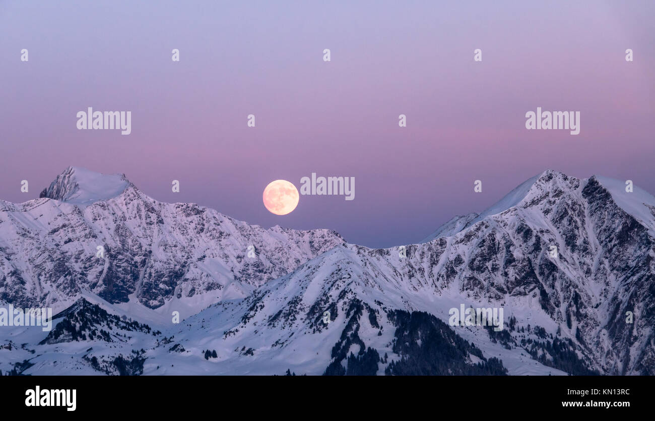 full moon rise over enchanting winter mountain landscape in the Swiss ...