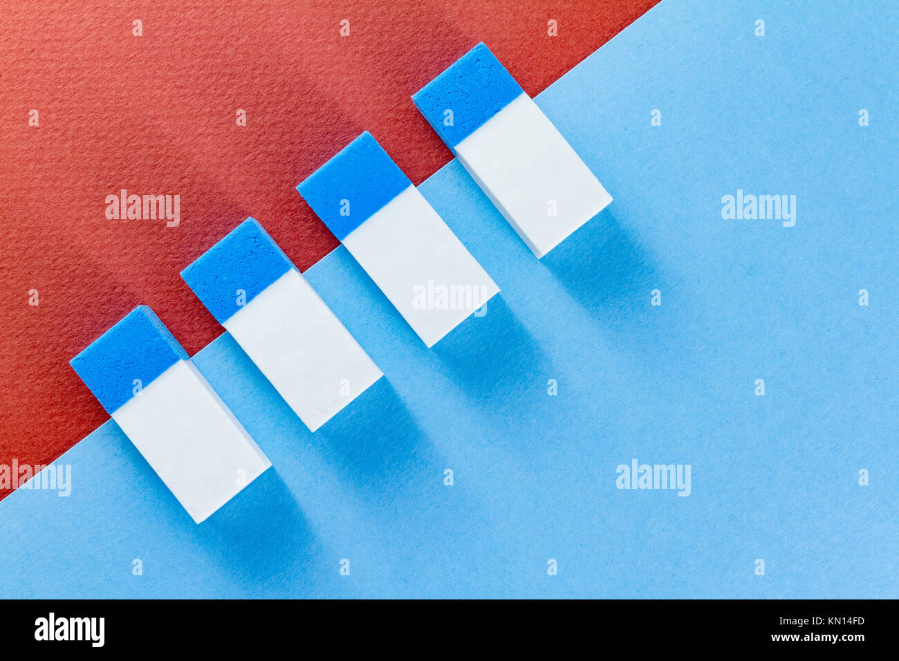 Top view of blue and white erasers on blue and brown color papers ...