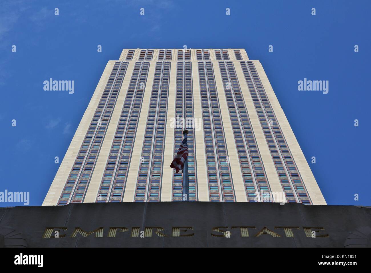 The Empire State Building rises into the stark blue sky in front of the ...