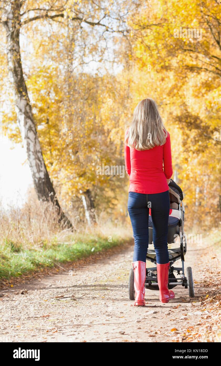 woman with a pram on walk in autumnal alley Stock Photo - Alamy