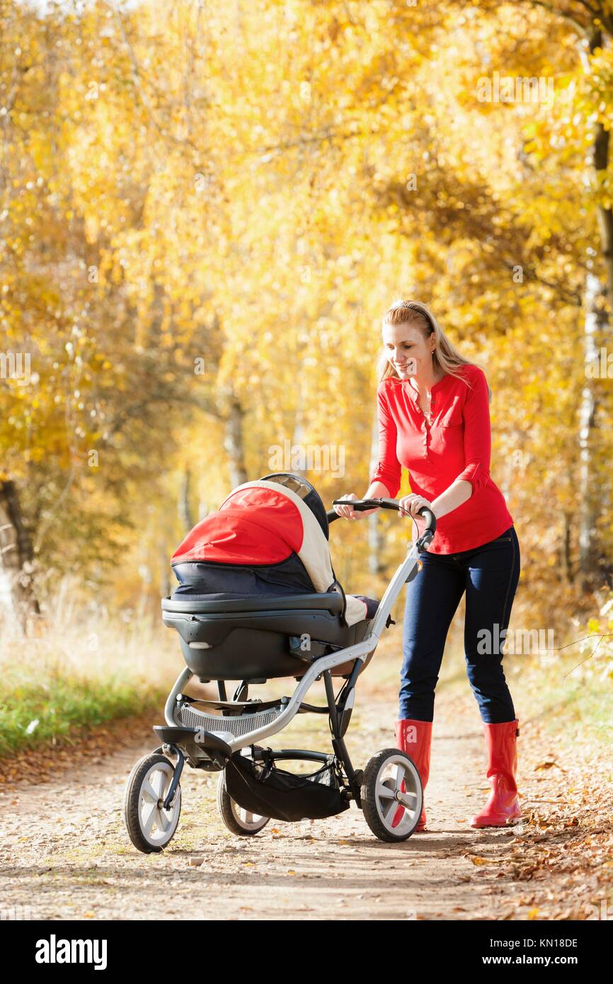 woman with a pram on walk in autumnal alley Stock Photo - Alamy