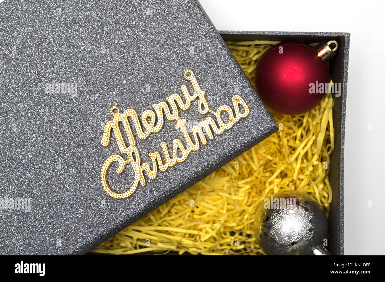 Merry christmas text and ball in black gift box with yellow packaging ...