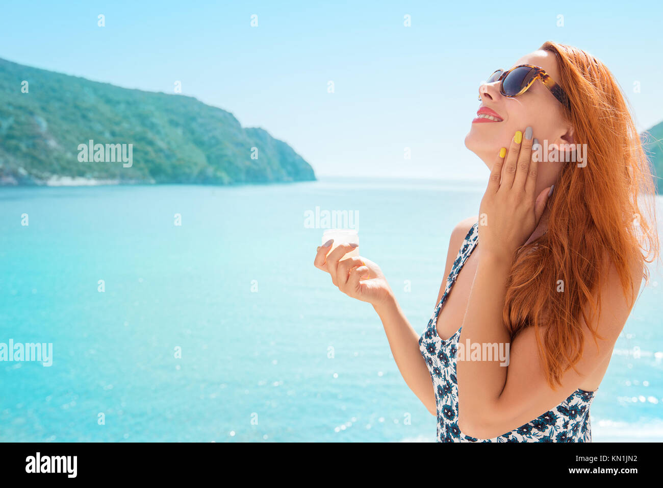 woman applying sunscreen sunblock lotion by seaside smiling happy ...