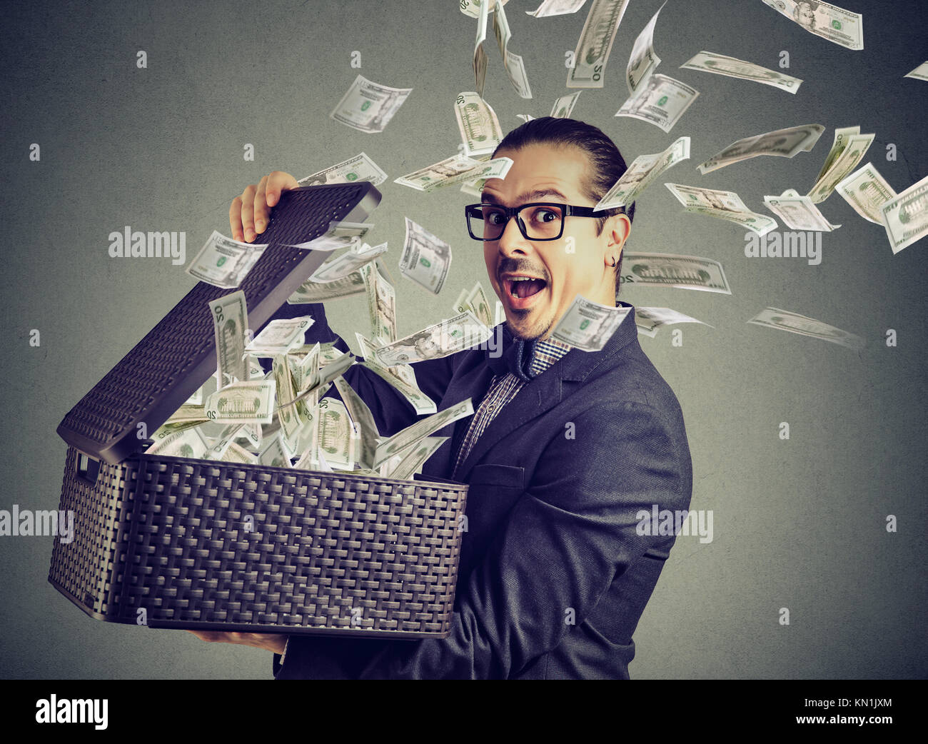 Excited successful business man opening a box with money flying out ...