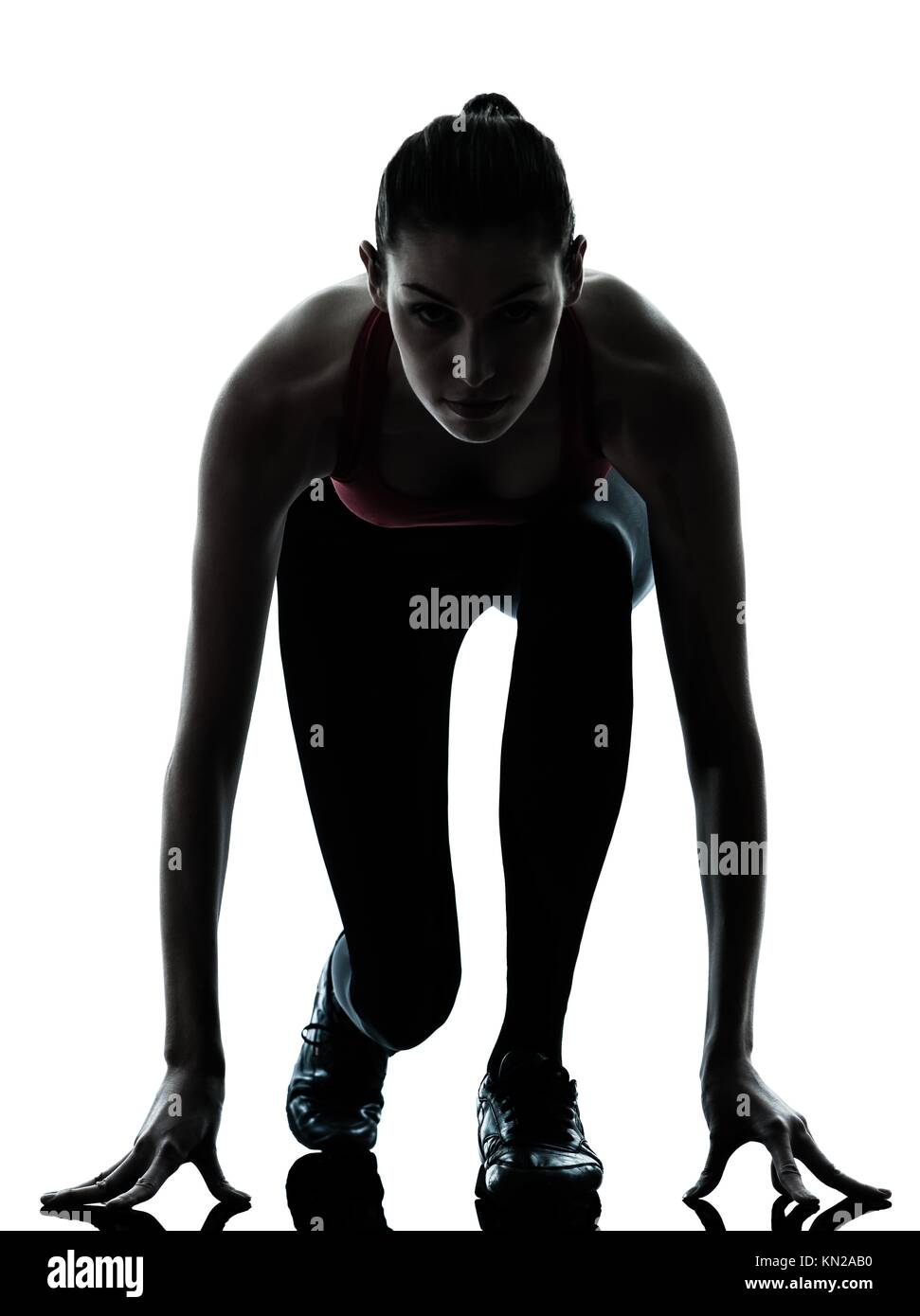 one caucasian woman sprinter on starting block in silhouette studio ...