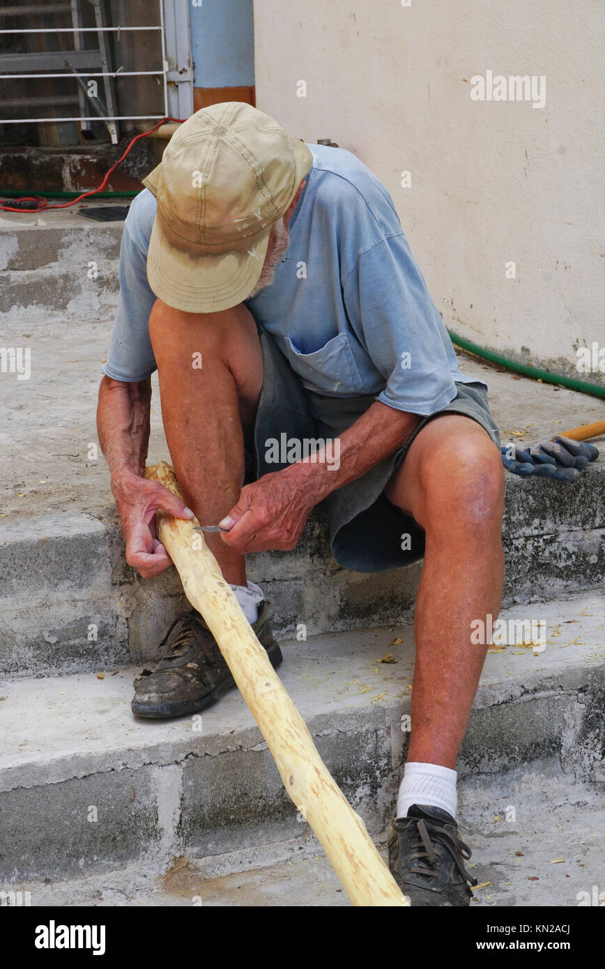 Mexican man scraping bark fron tree limbs to make stair railings ...