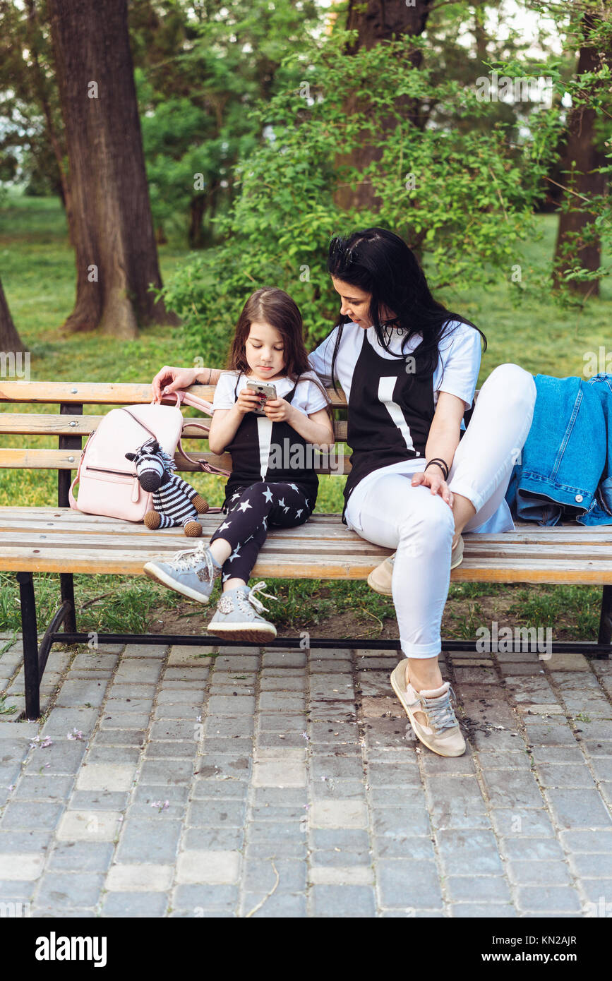 mom and daughter rest on the bench Stock Photo - Alamy