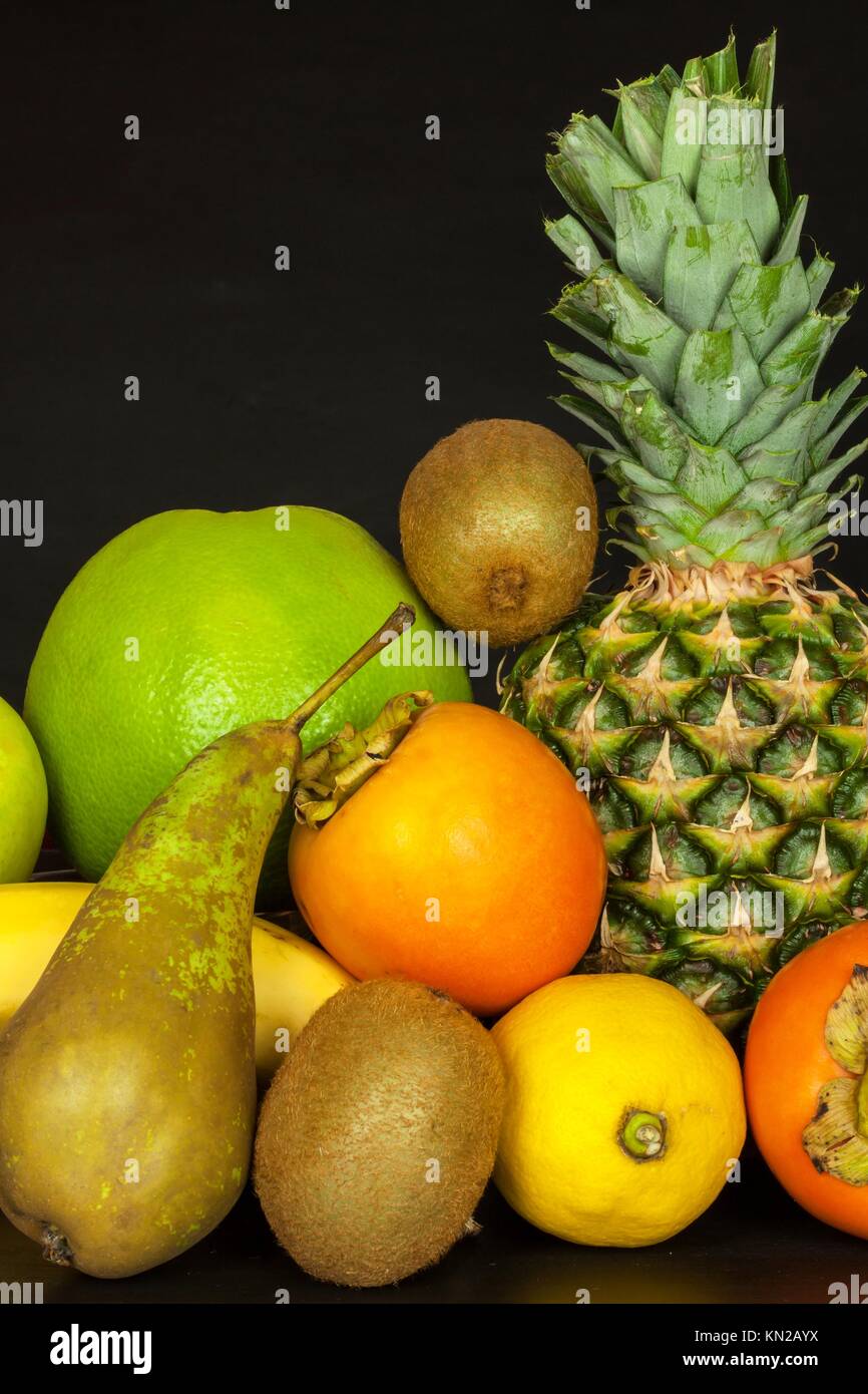 Different fruits on a black kitchen table. Food for athletes. Vitamins ...