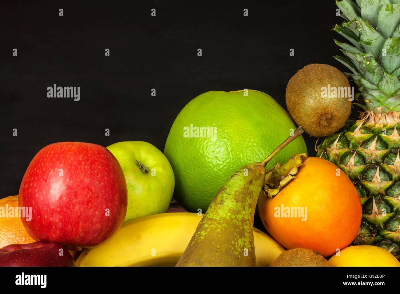 Different fruits on a black kitchen table. Food for athletes. Vitamins ...