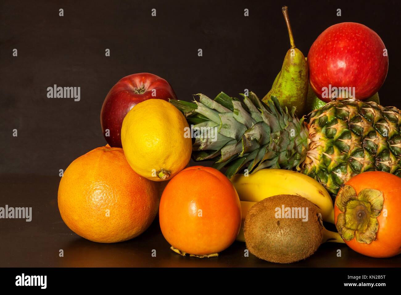 Different fruits on a black kitchen table. Food for athletes. Vitamins ...