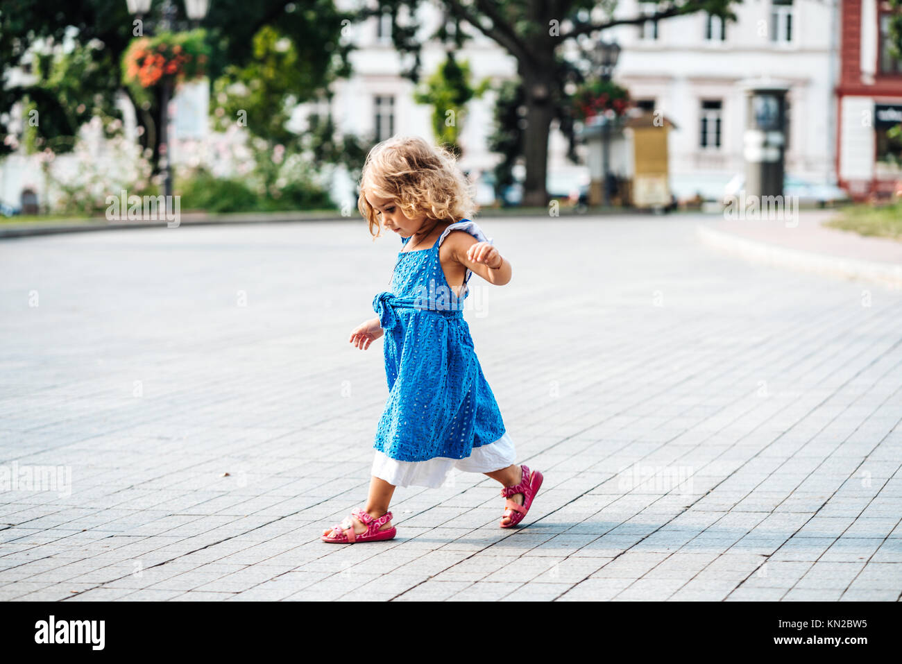 Beautiful little girl walking in the sun Stock Photo - Alamy