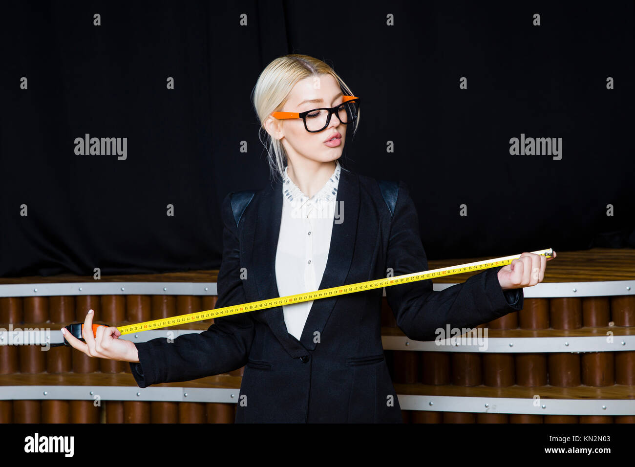 Beautiful blonde businesswoman with tape measure at loft office in ...