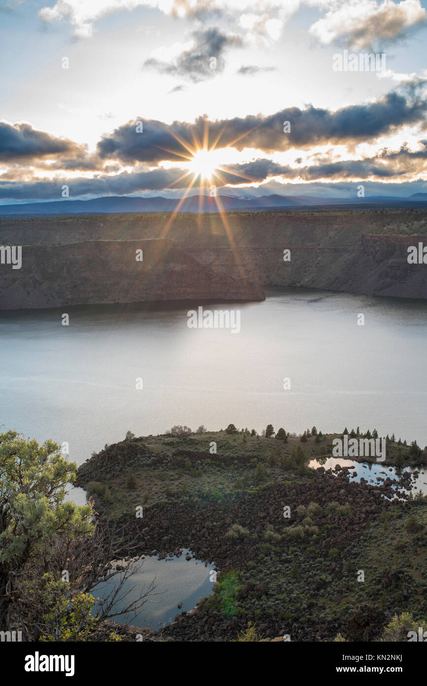 Clouds part to let sunset make a sun star over the water of the Cove ...