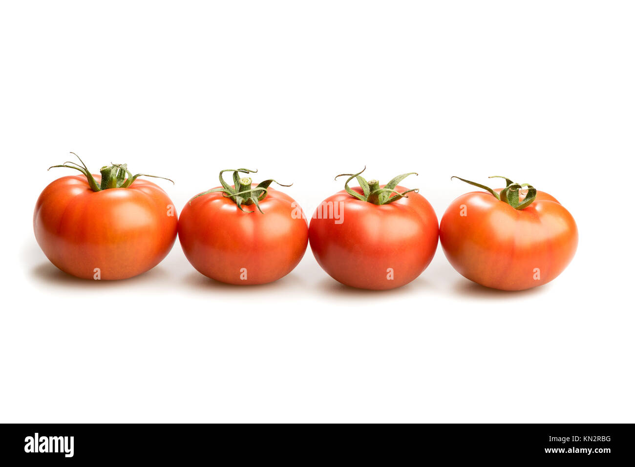 Four realistic looking fresh red tomatoes lying in a line isolated in a ...