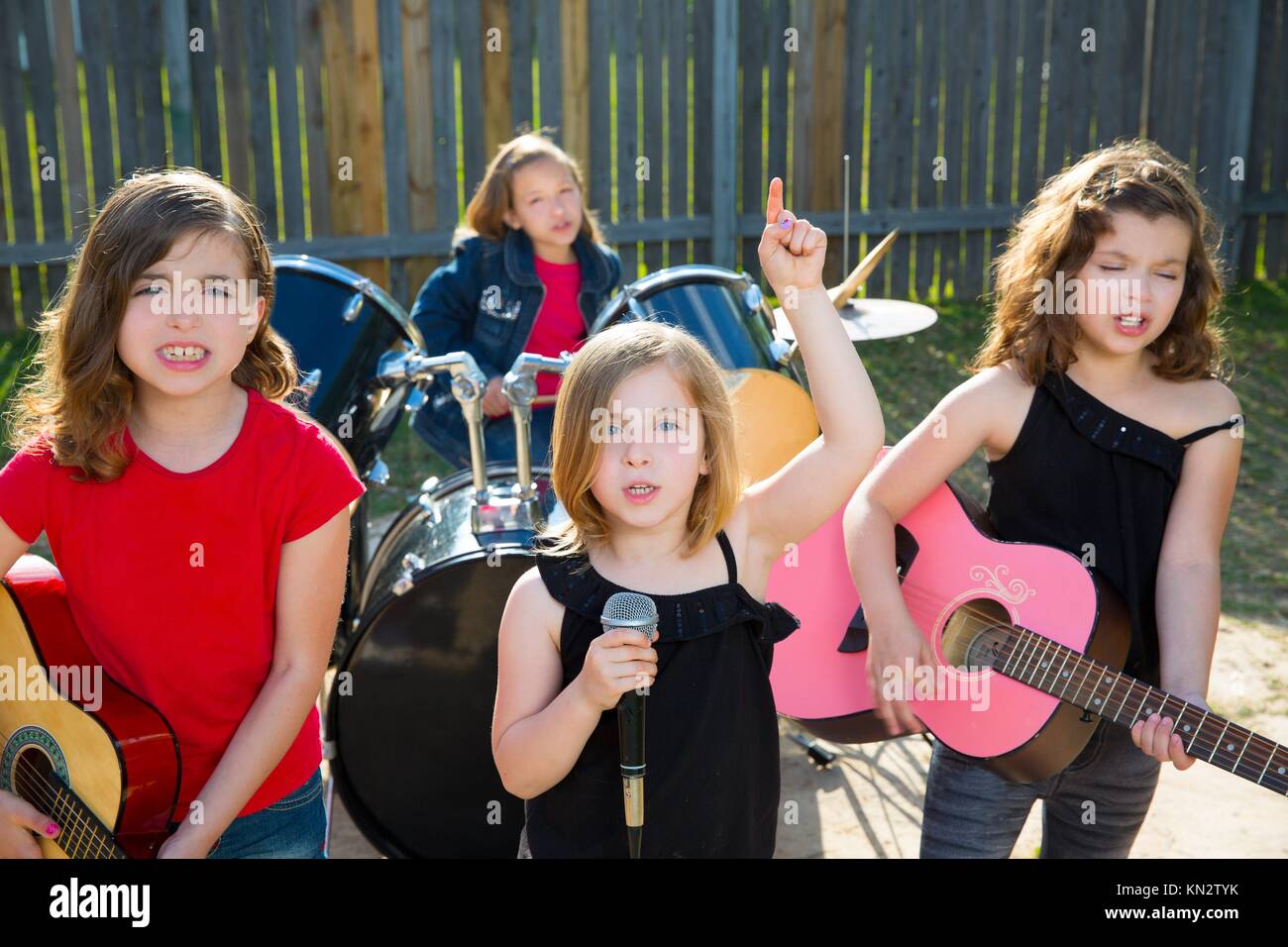 Blond kid singer girl singing playing live band in backyard concert ...