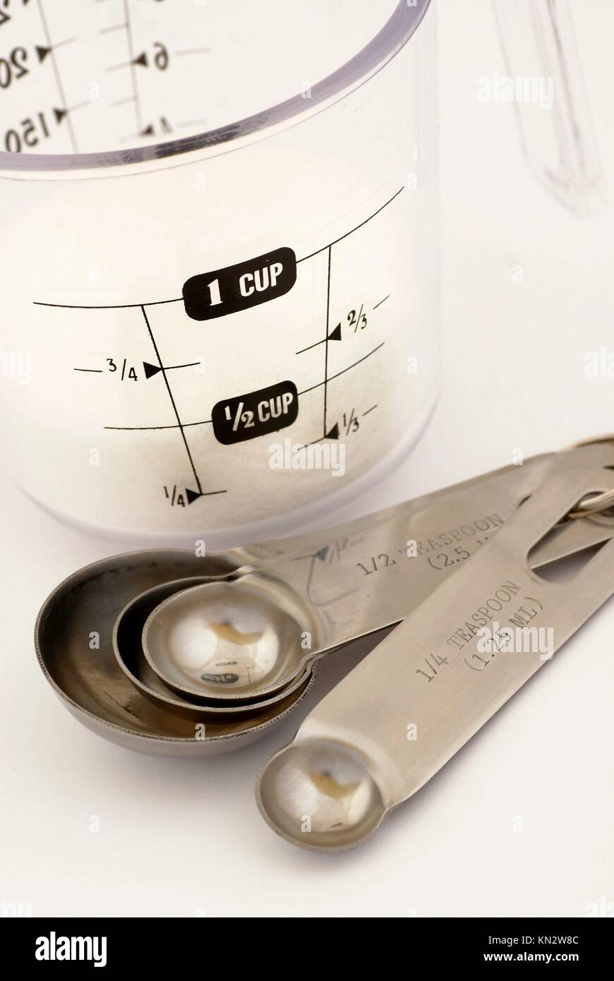 Measuring cup with sugar and measuring spoons on white background Stock ...