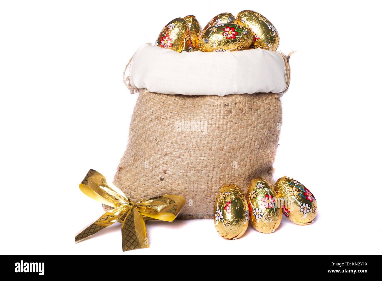 Close up view of sweet golden eggs inside a sack isolated on a white ...