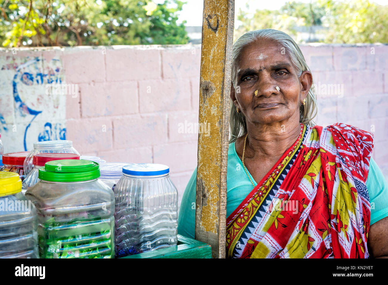 Female Indian street trader posing for a picture at the side of her ...