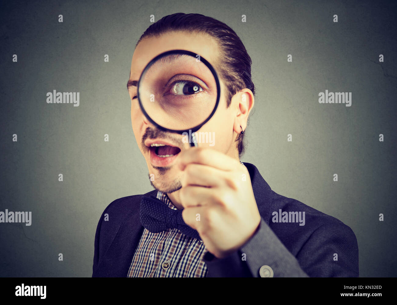 Curious business man looking through a magnifying glass Stock Photo - Alamy