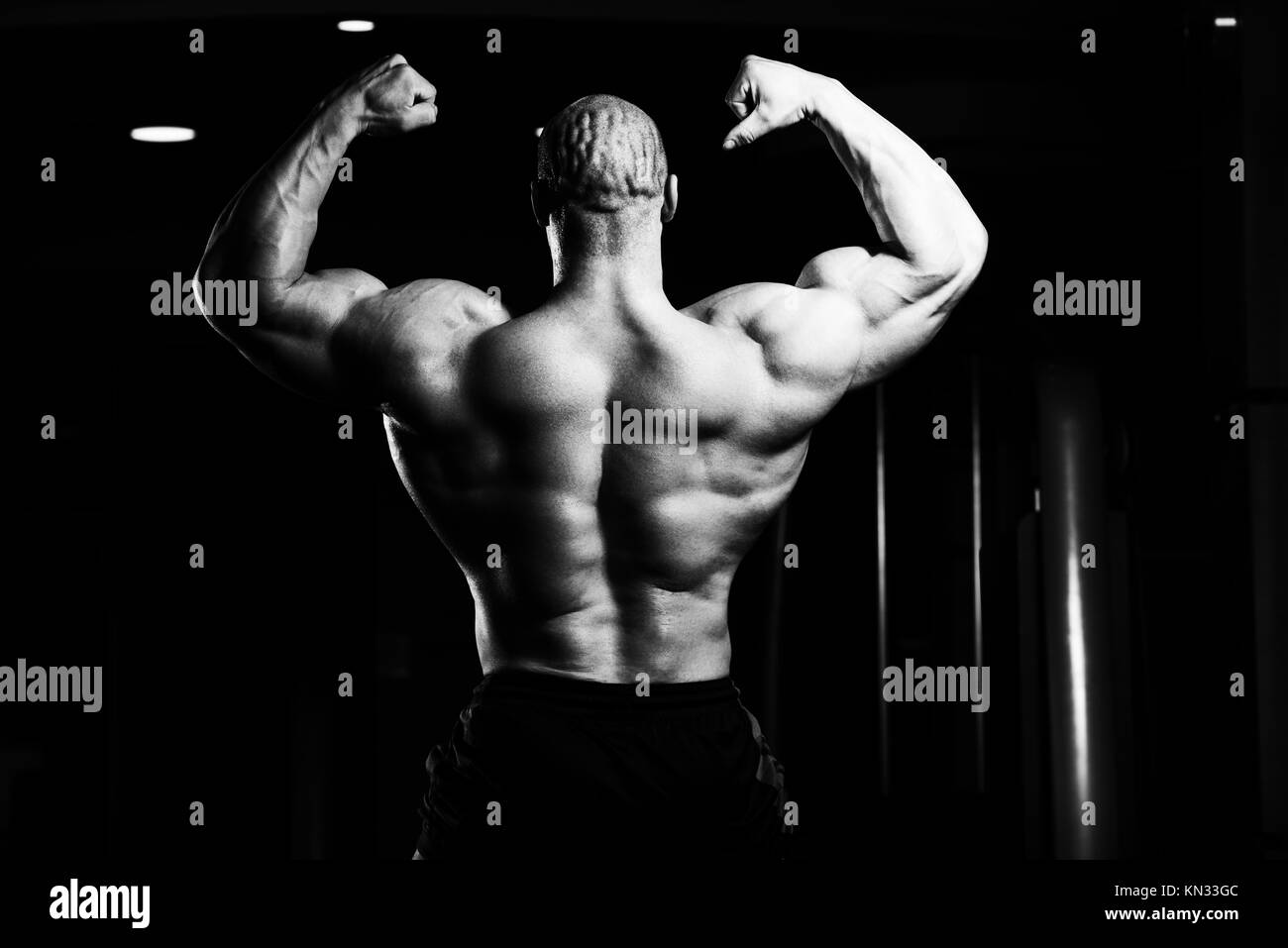Healthy Young Man Standing Strong In The Gym And Flexing Muscles ...