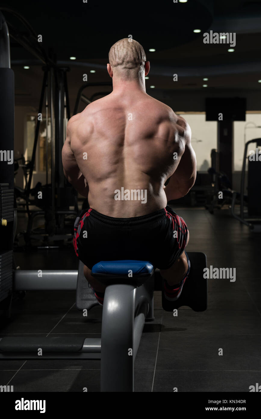 Handsome Bodybuilder Doing Heavy Weight Exercise For Back On Machine ...