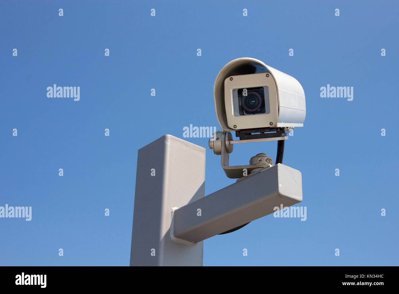 Security camera facing left before the background of a clear blue sky ...