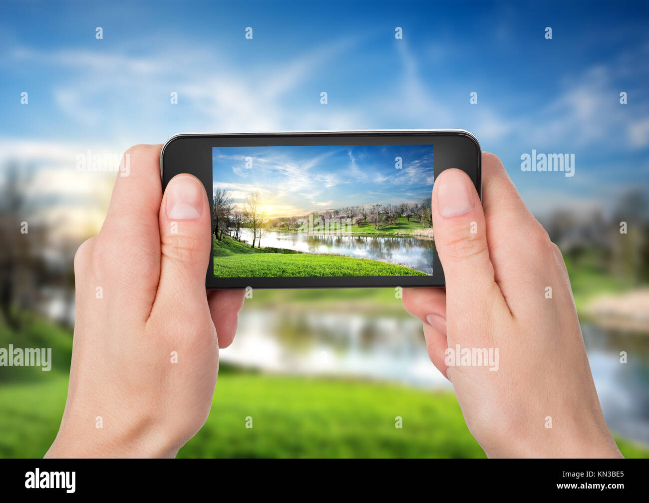 Mobile phone in hand and spring landscape Stock Photo - Alamy