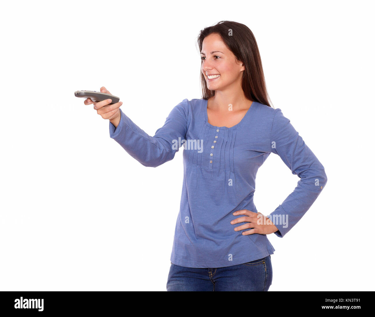 Portrait of a lovely young female pointing remote control while ...