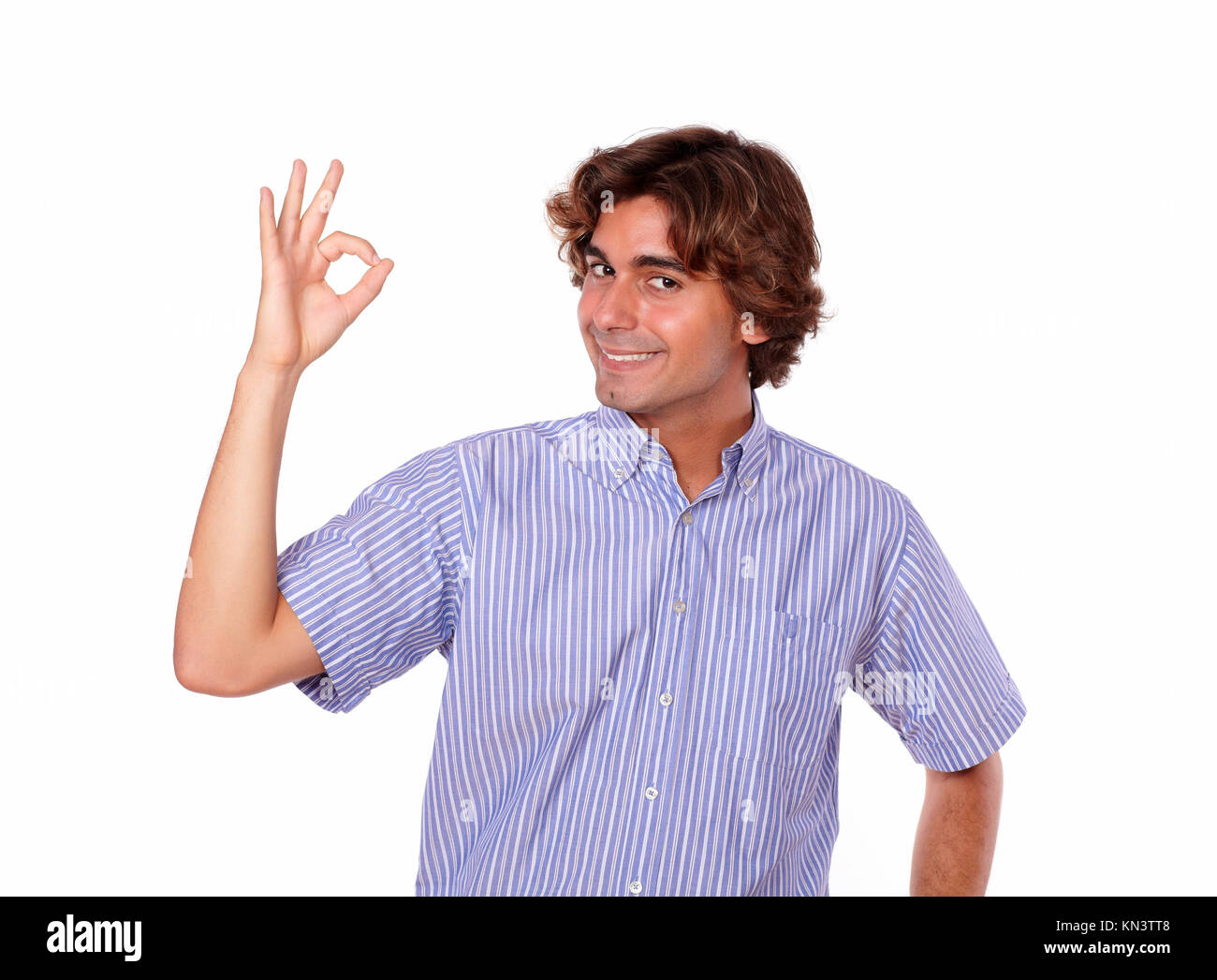 Portrait of a young man smiling and showing people ok sign while is ...