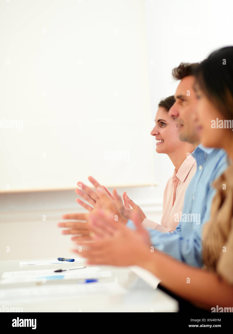 Portrait of professional man and women giving applause and listen while ...