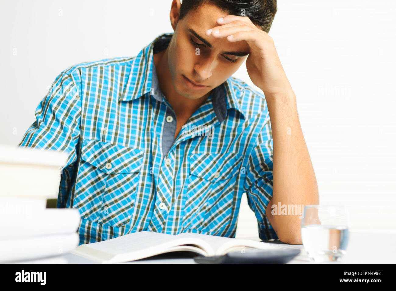 Young man concentrating while reading a book Stock Photo - Alamy