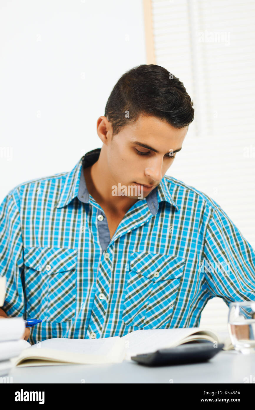 Young man concentrating while studying Stock Photo - Alamy