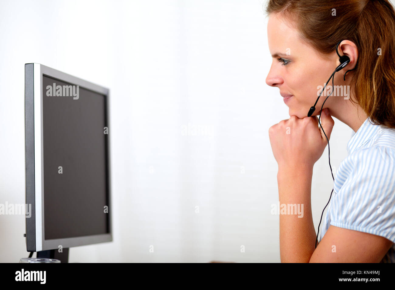 Portrait of a blonde friendly secretary looking the computer screen ...