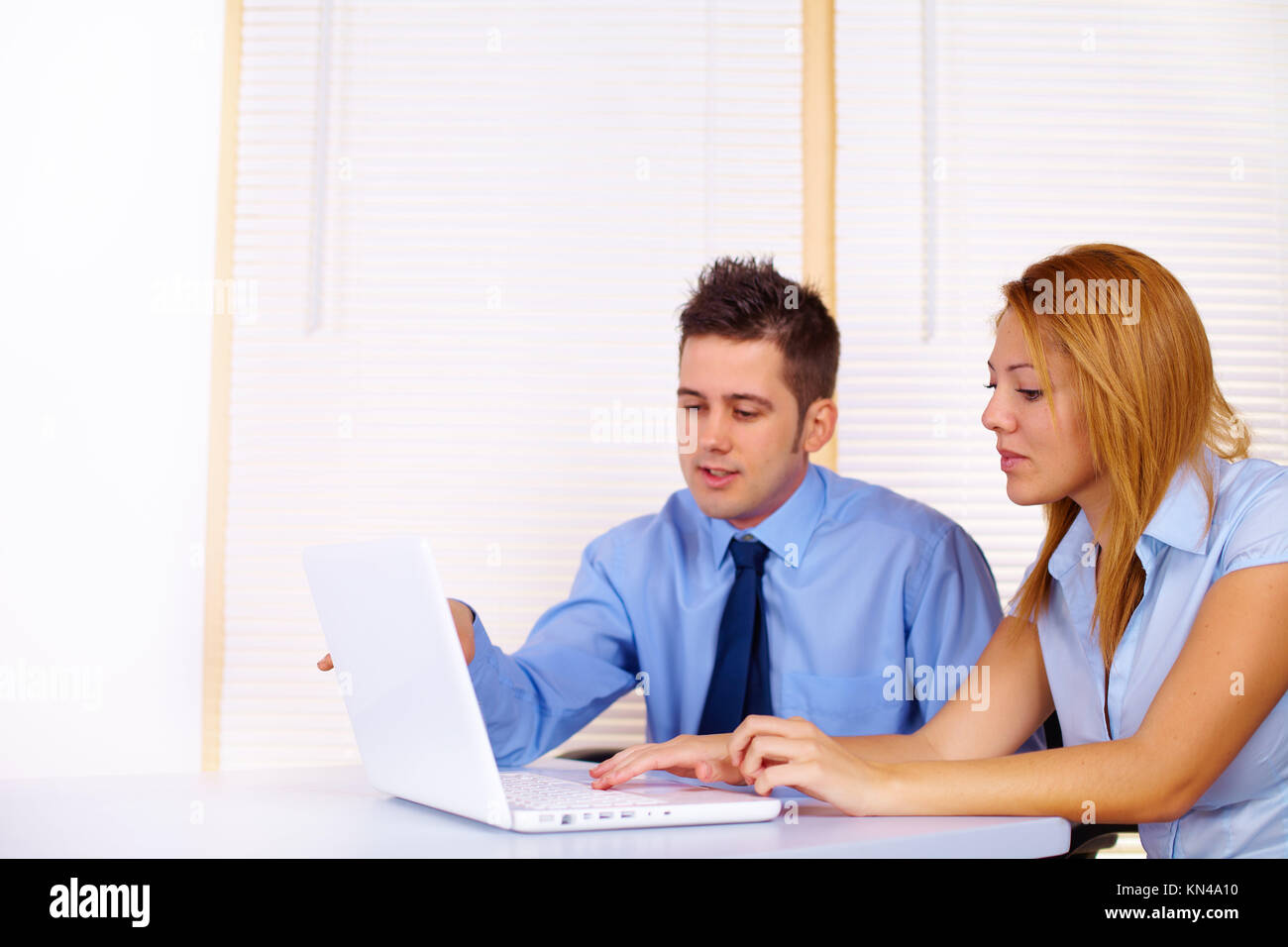 Portrait of two business people working with a laptop Stock Photo - Alamy