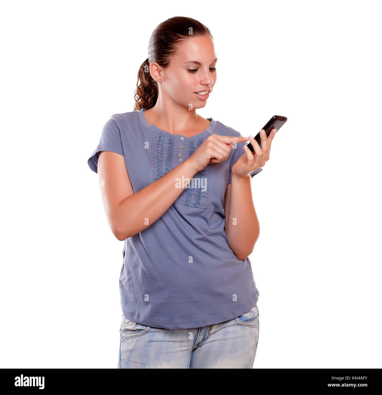 Charming young woman sending message by cellphone standing over white ...