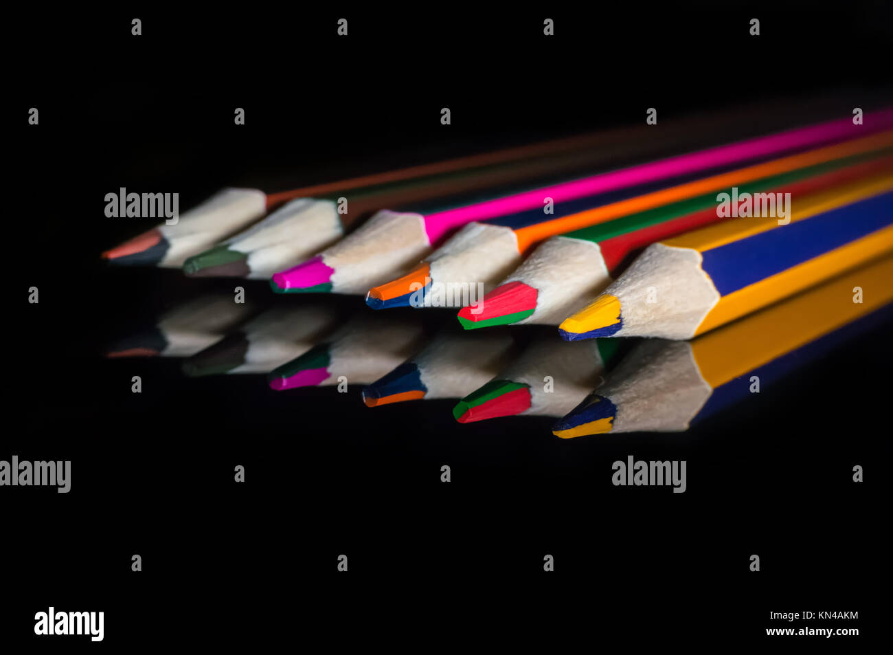 Coloured pencils on a reflective glass mirror surface. Pencils with ...