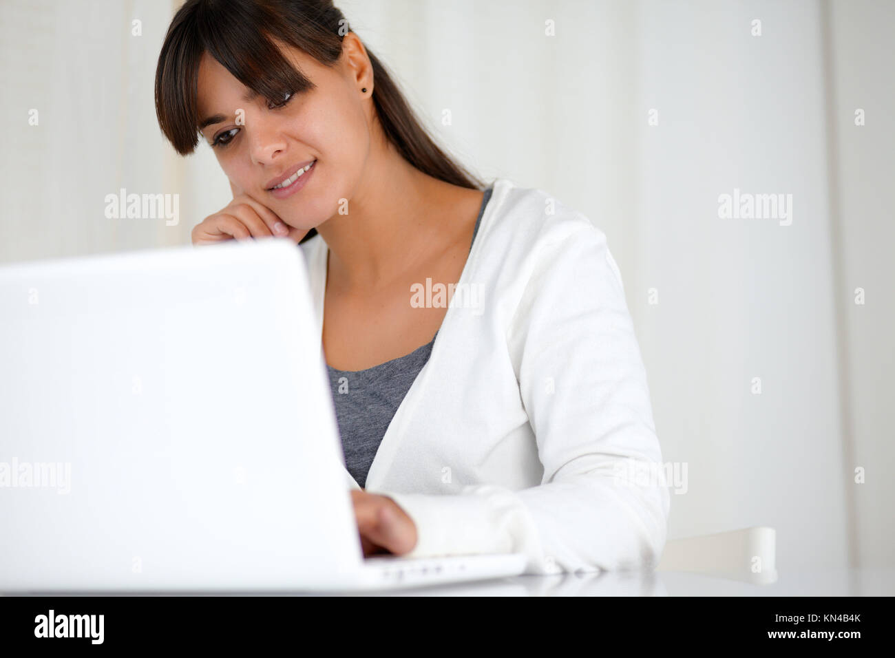 Portrait of a pretty young woman reading the laptop screen Stock Photo ...