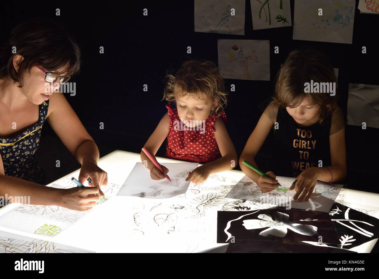 Young girls and mother enjoy a day of art work, drawing and imagination ...
