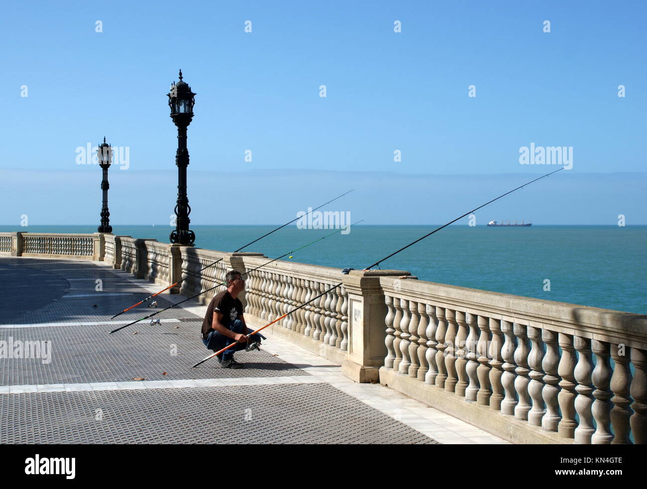 Man fishing on Cadiz sea wall waterfront, Cadiz,Spain Stock Photo - Alamy